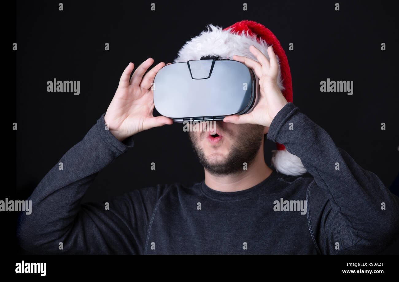 Image of surprised man in Santa's cap and glasses of virtual reality ...