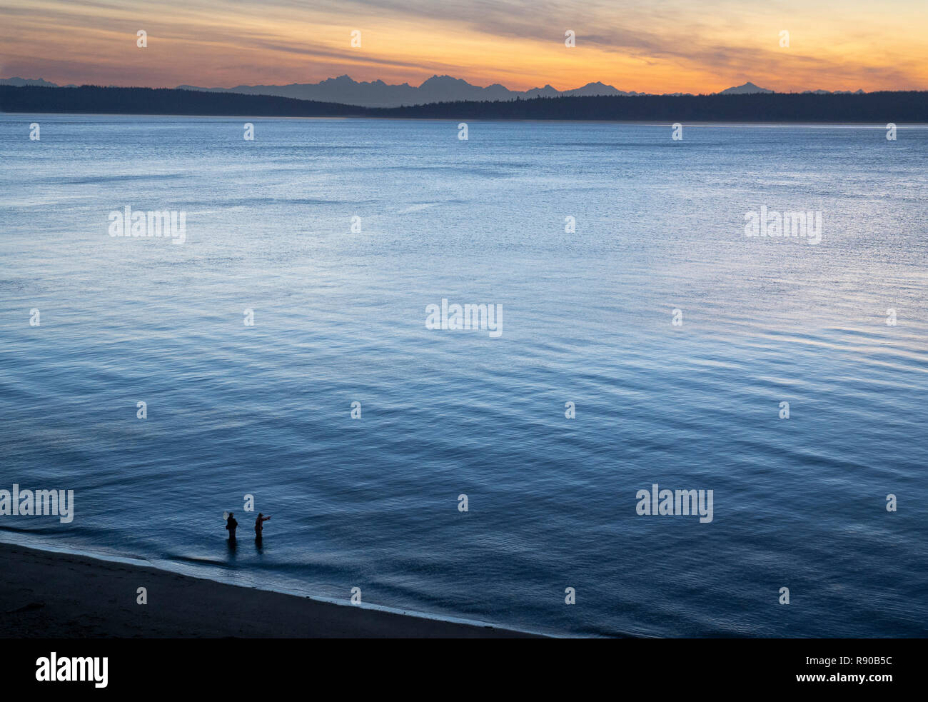 A view from above of a guide and a fly fisherman at the water's edge ...
