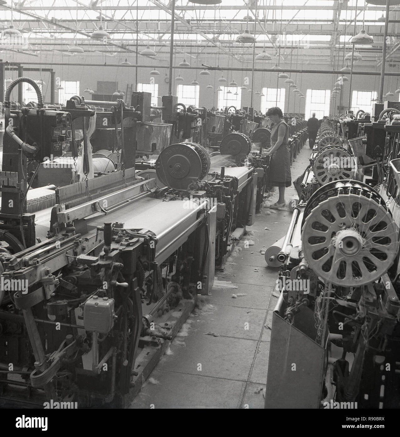 1950s, historical, a female worker on a factory floor standing using ...