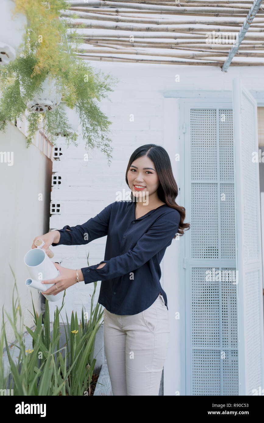 Beautiful young woman gardening outside in summer nature Stock Photo ...