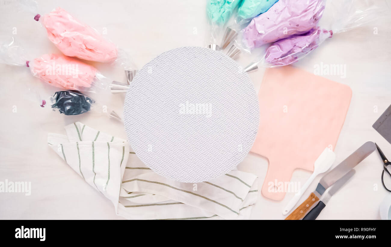 Flat lay. Frosting pink and purple cake with a white buttercream icing ...
