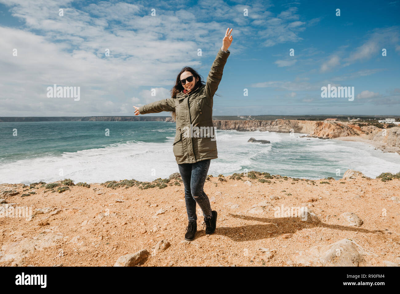 A young beautiful girl against the backdrop of the Atlantic Ocean and ...