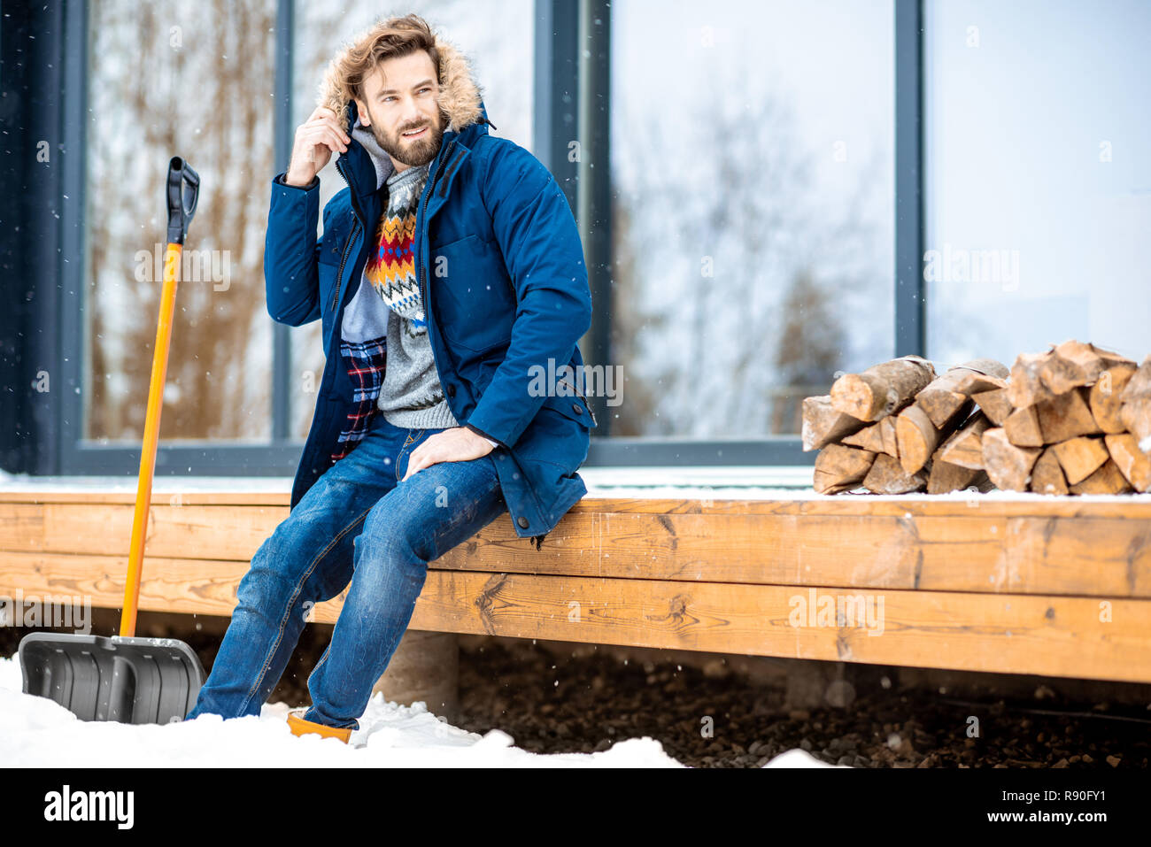Portrait of a handsome man in winter clothes filling cold sitting on ...