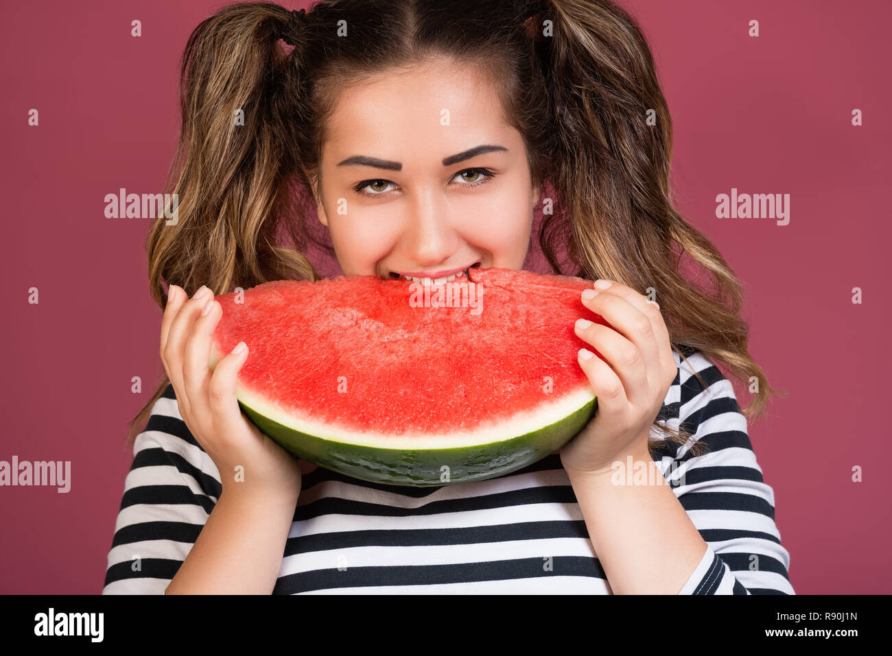 Funny portrait happy smiling young woman eating a slice of watermelon ...