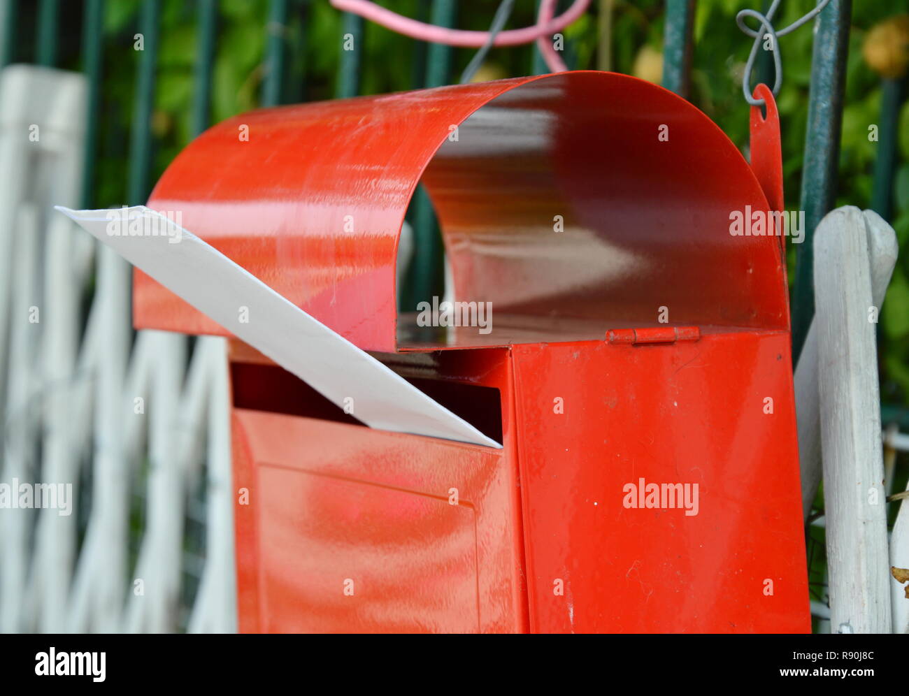 letter in red post box on home fence Stock Photo - Alamy