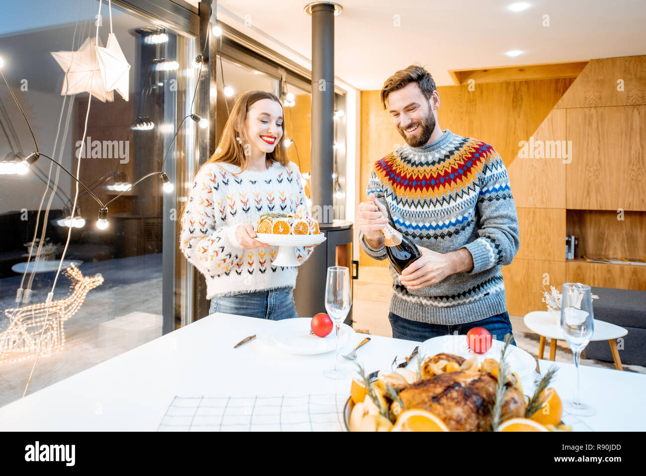 Young couple having festive dinner sitting together in the modern house ...