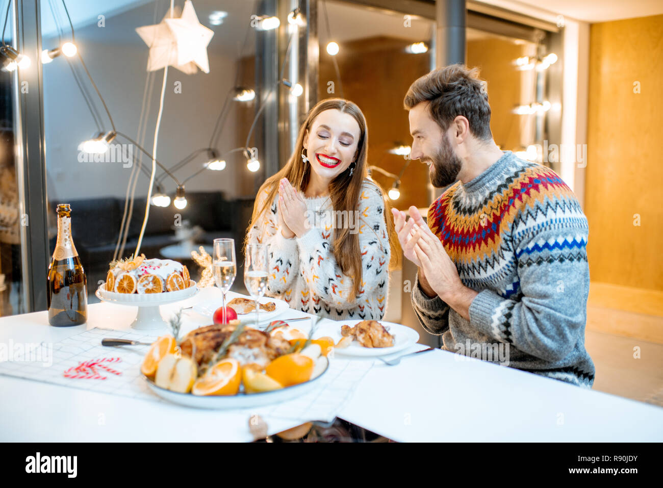 Young couple having festive dinner sitting together in the modern house ...