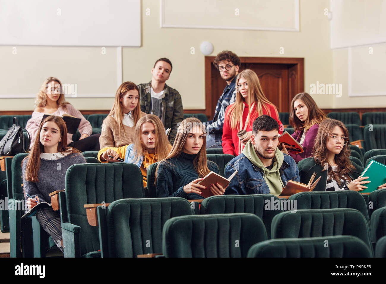 The group of cheerful students sitting in a lecture hall before lesson ...
