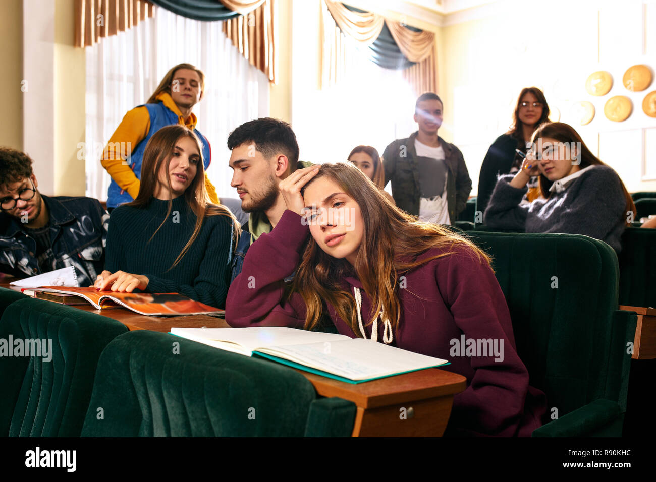 The group of cheerful students sitting in a lecture hall before lesson ...