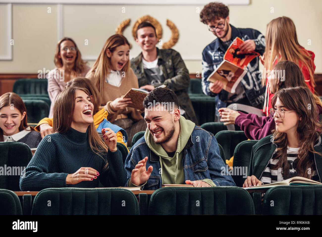 The group of cheerful students sitting in a lecture hall before lesson ...