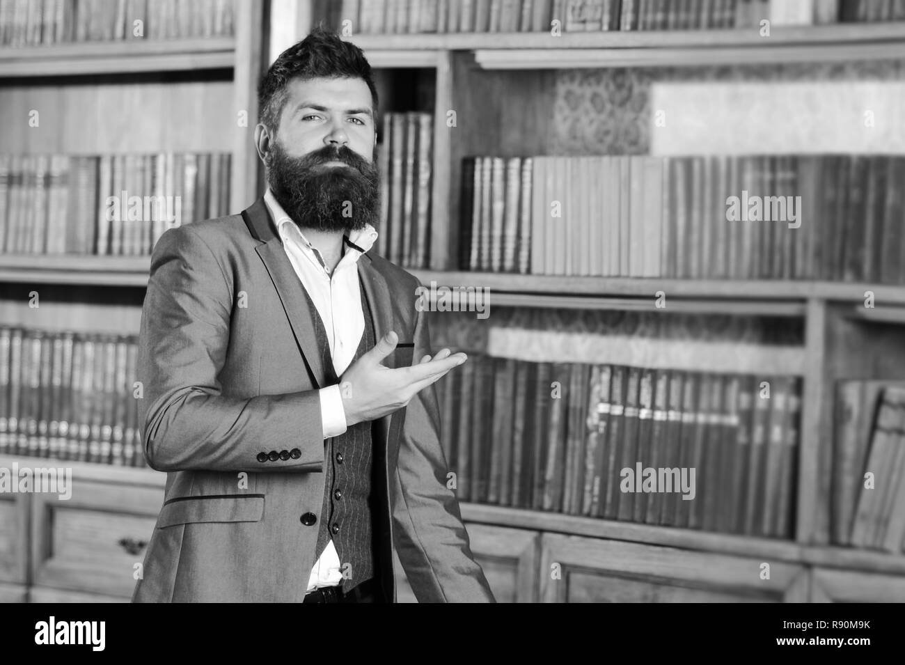 Smart business man standing near bookcase in vintage library Stock ...