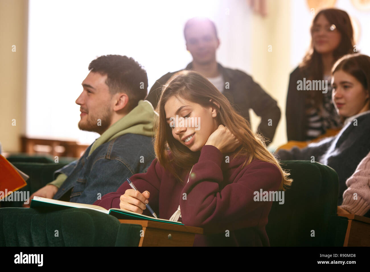 The group of cheerful students sitting in a lecture hall before lesson ...