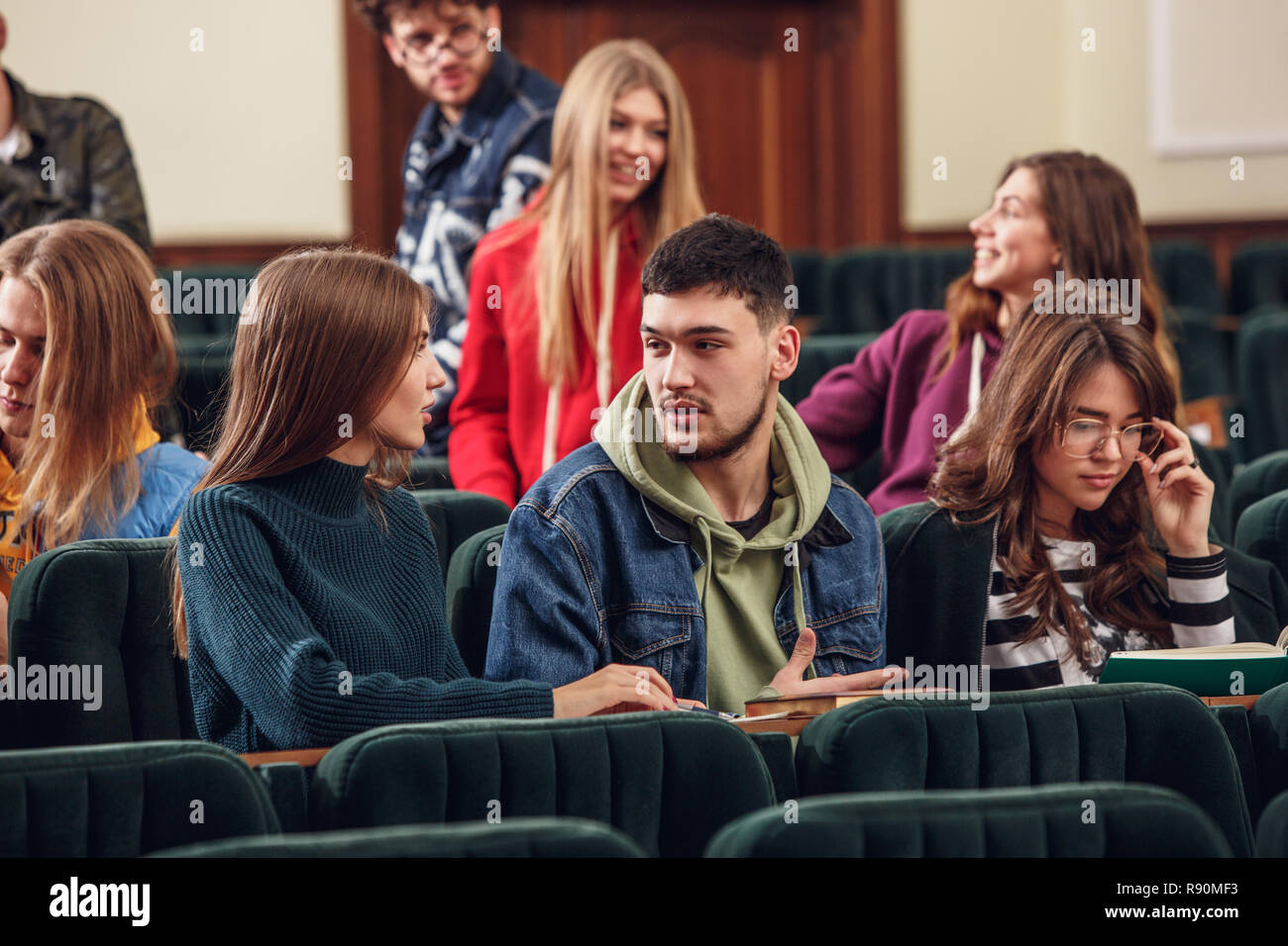 The group of cheerful students sitting in a lecture hall before lesson ...