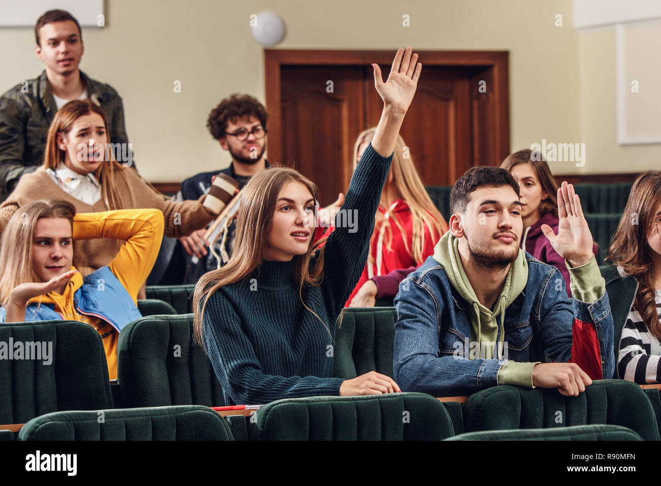 The group of cheerful students sitting in a lecture hall before lesson ...