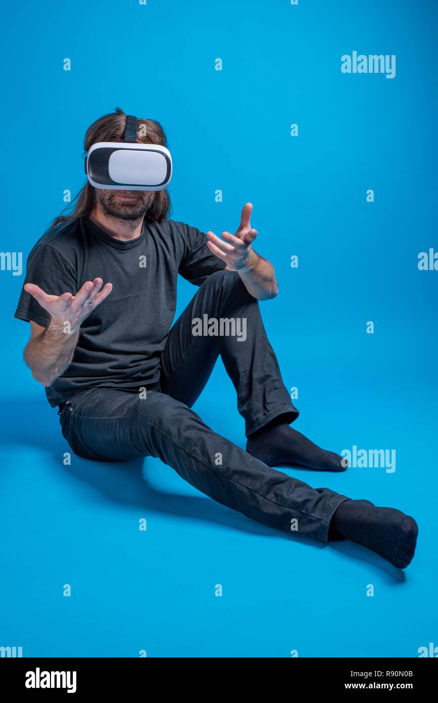 Portrait of a man standing down gesturing with his hands and enjoying a ...