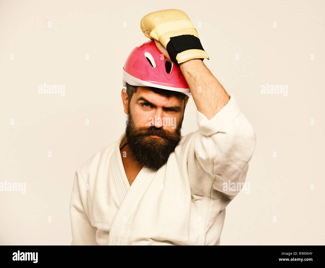 Man with beard in kimono and pink helmet on white background. Combat ...