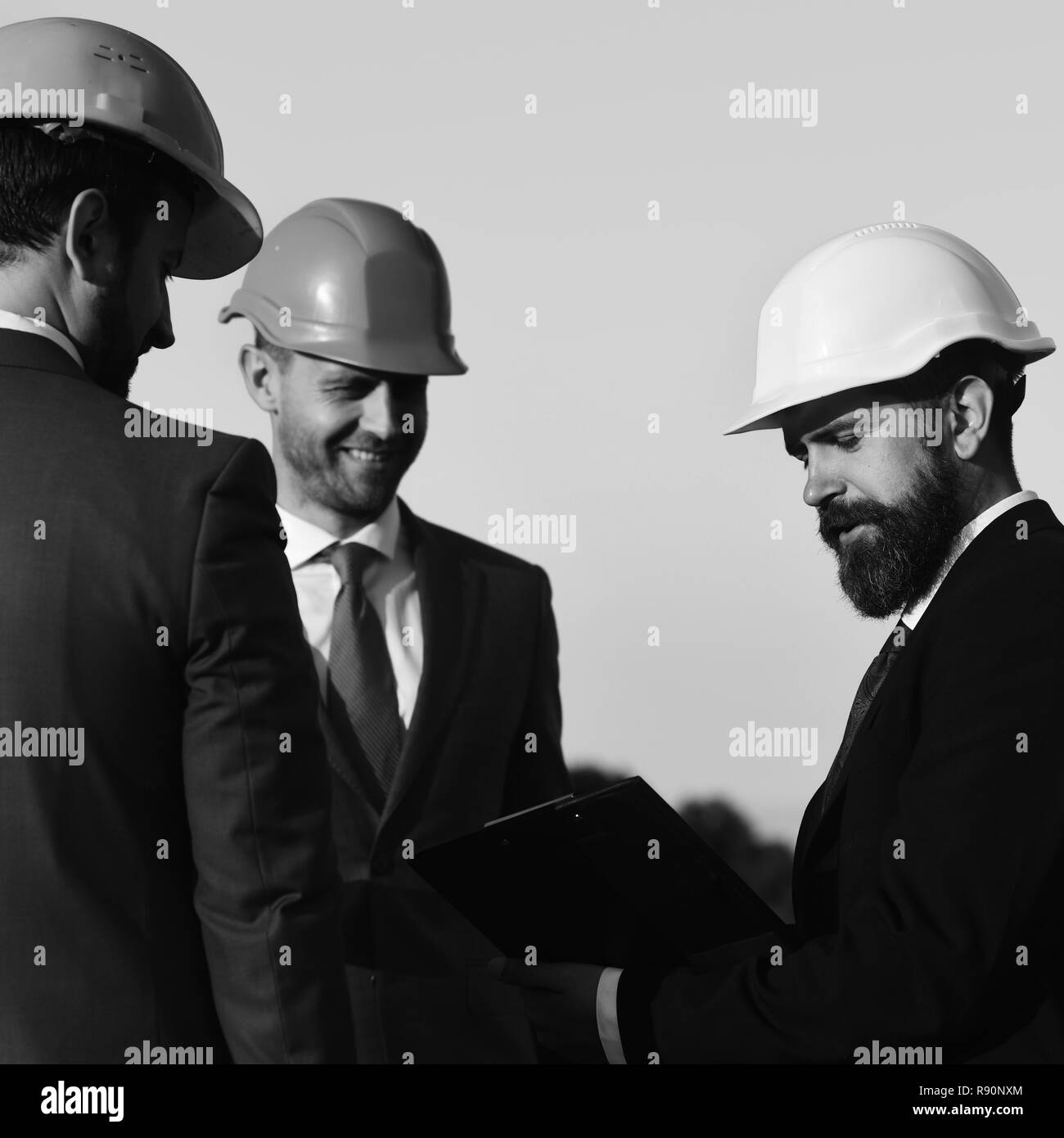 Construction concept. Men with beard and smiling faces check project ...