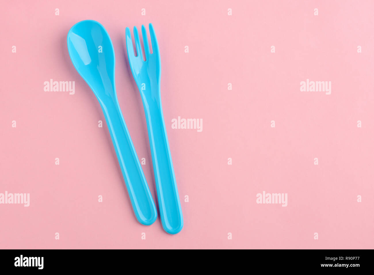 Set of blue spoon and fork on pink background with copy space. Colorful ...