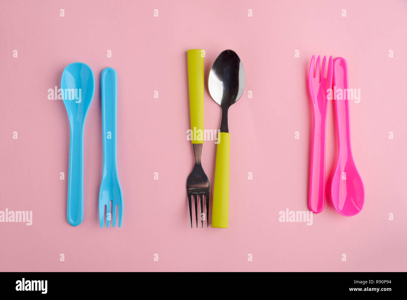 Different cutlery sets on pink background. Various colors, plastic and ...