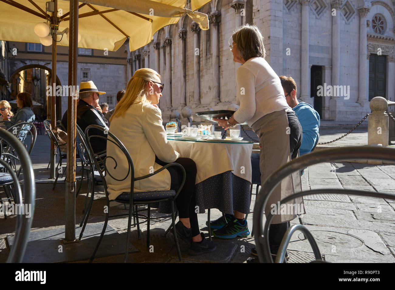 Lucca, Italy: waitress serving couple coffee in piazza Stock Photo - Alamy