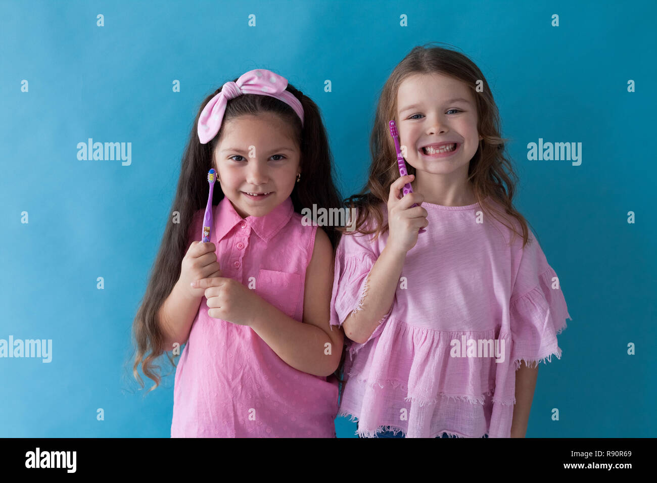 two young girls show toothbrushes dentistry nice Stock Photo - Alamy