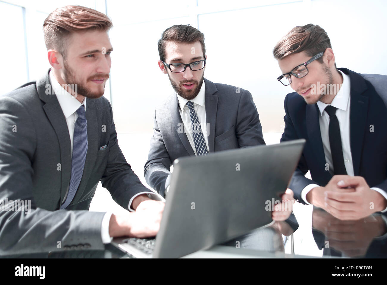 three businessman sitting at his Desk Stock Photo - Alamy