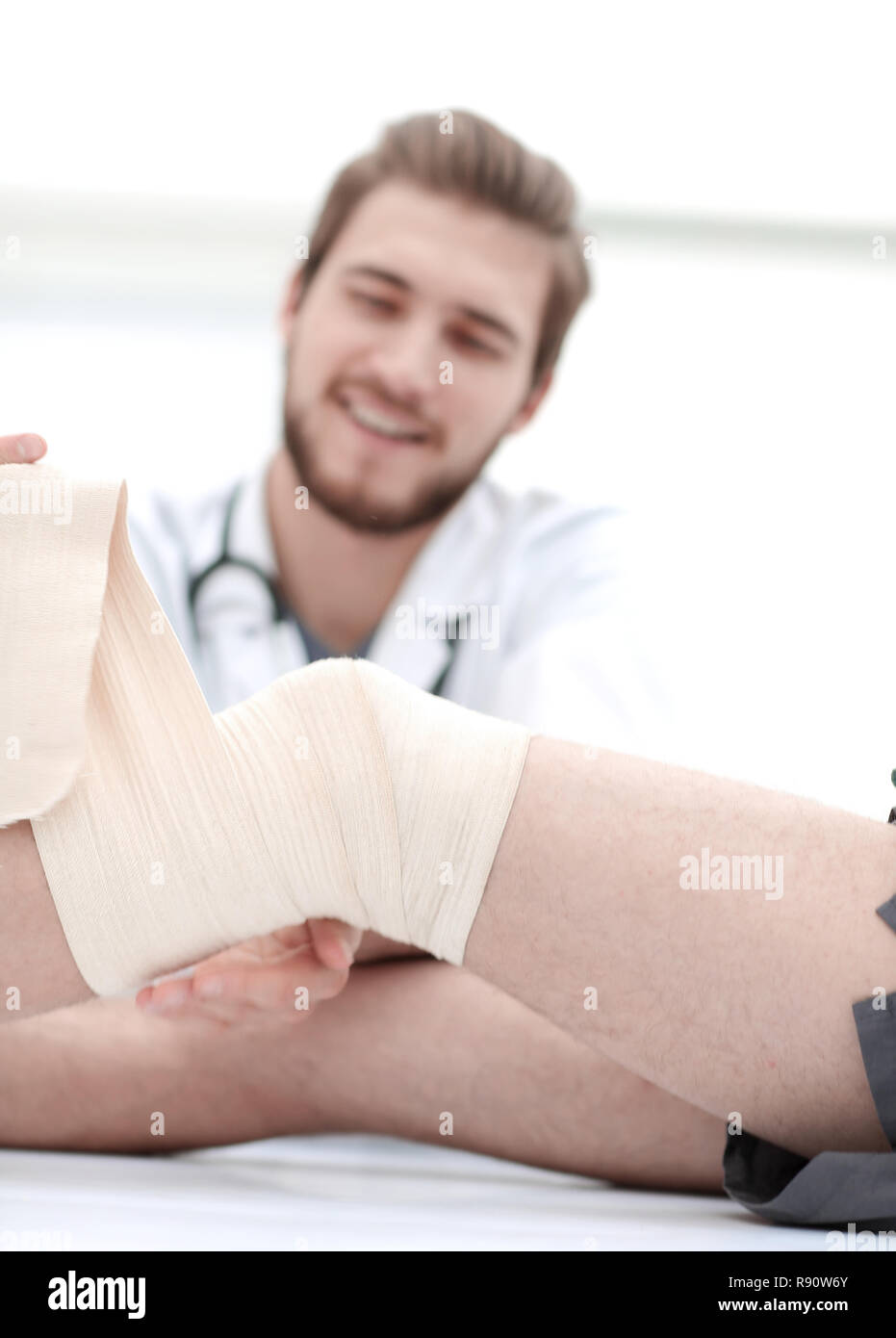 doctor bandaging a wound on the leg of the patient Stock Photo - Alamy