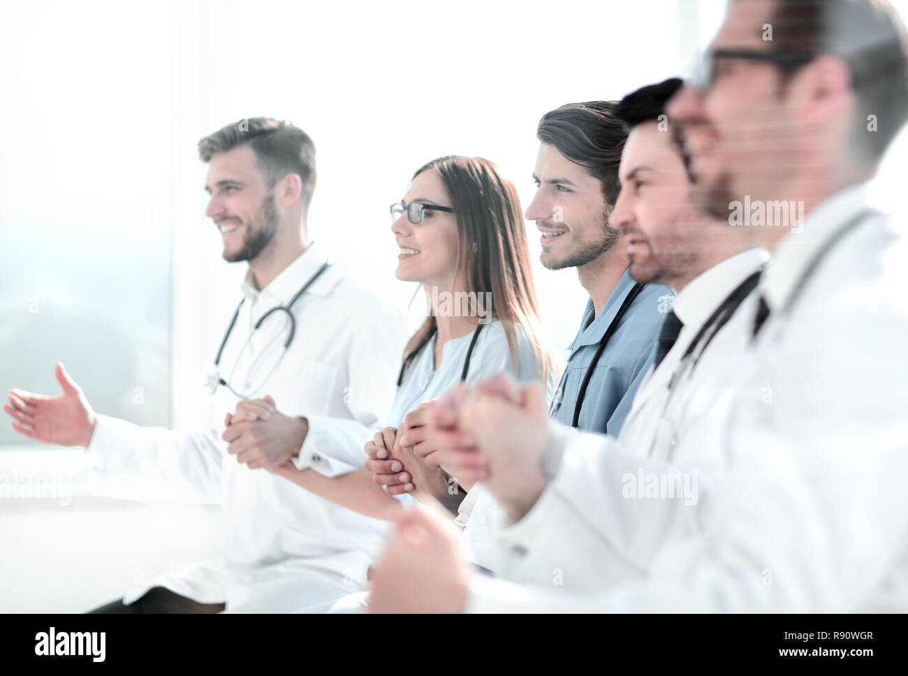 doctors sit in a row and hold hands of each other Stock Photo - Alamy
