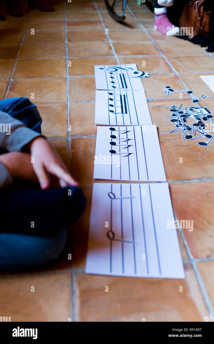 cropped view of an eleven year old boys' hands composing music with cut ...