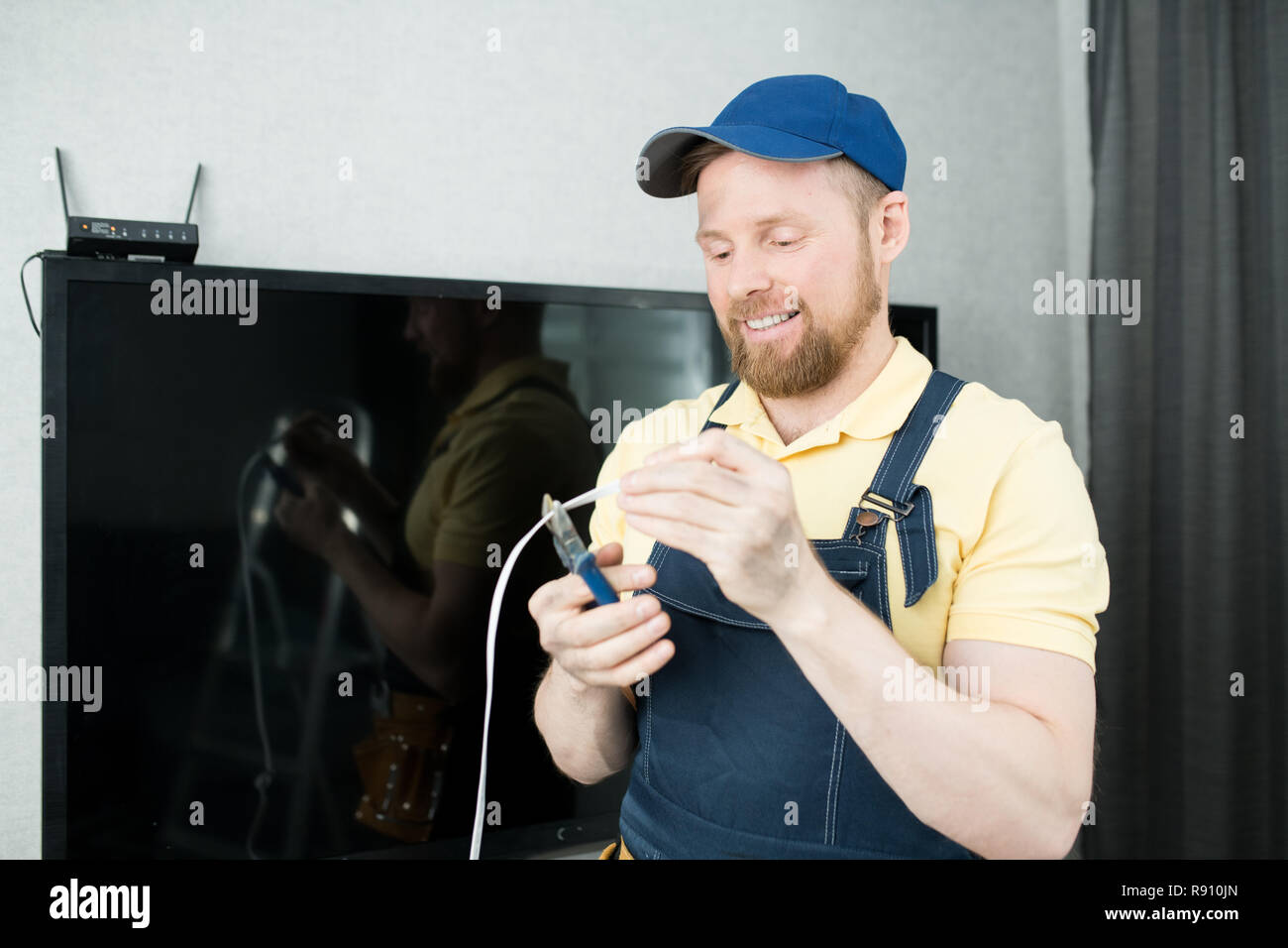 Cheerful guy cutting wire Stock Photo - Alamy