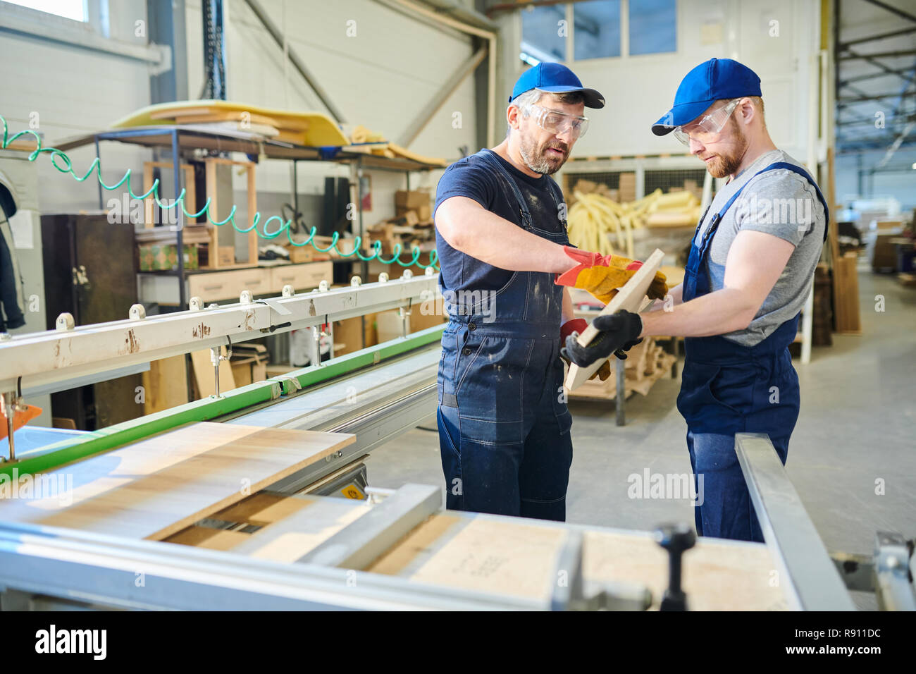 Engineers examining wooden plank at factory Stock Photo - Alamy