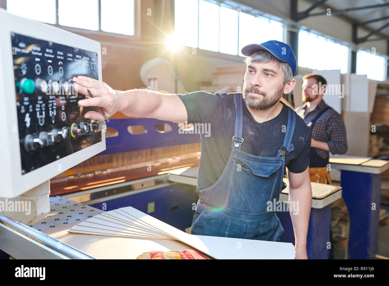 Serious handsome workman setting up factory machine Stock Photo - Alamy
