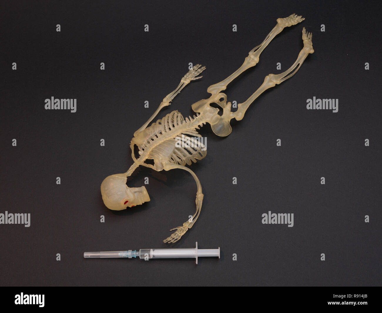 flat lay of human body skeleton on the ground floor with syringe drugs ...
