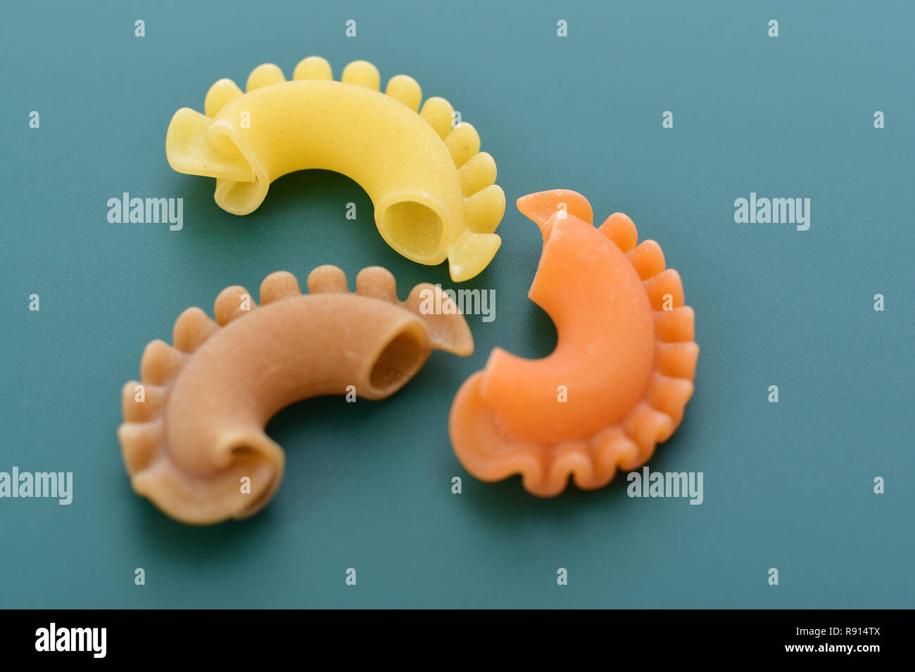 Pasta creste di gallo on green background Stock Photo - Alamy