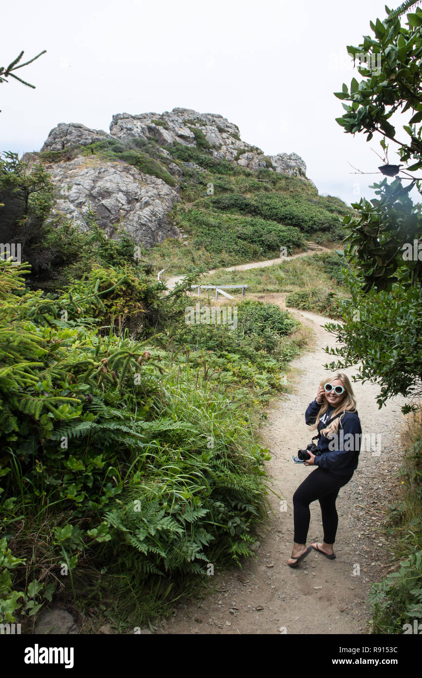 An adult female hiker stands in lush vegetation of Patricks Point State ...
