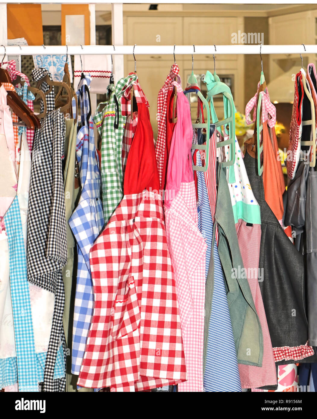 Colorful decorative aprons with retro pattern designs hanging on ...