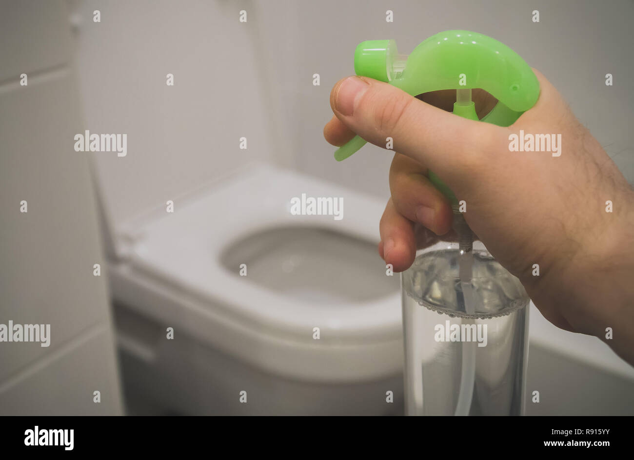 Male hand spraying toilet air freshener at home Stock Photo - Alamy