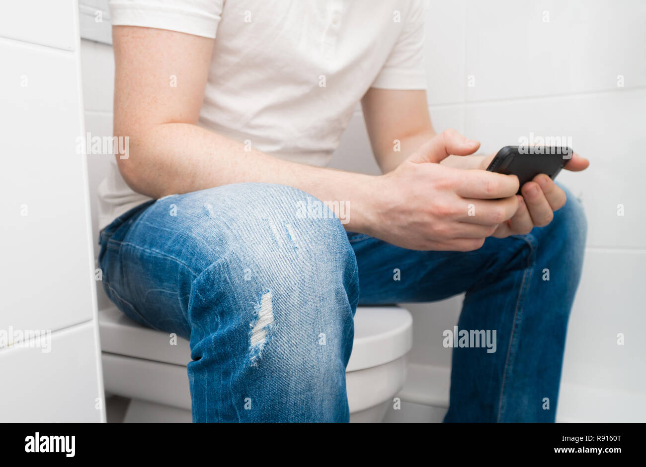 Man using mobile phone in the toilet Stock Photo - Alamy
