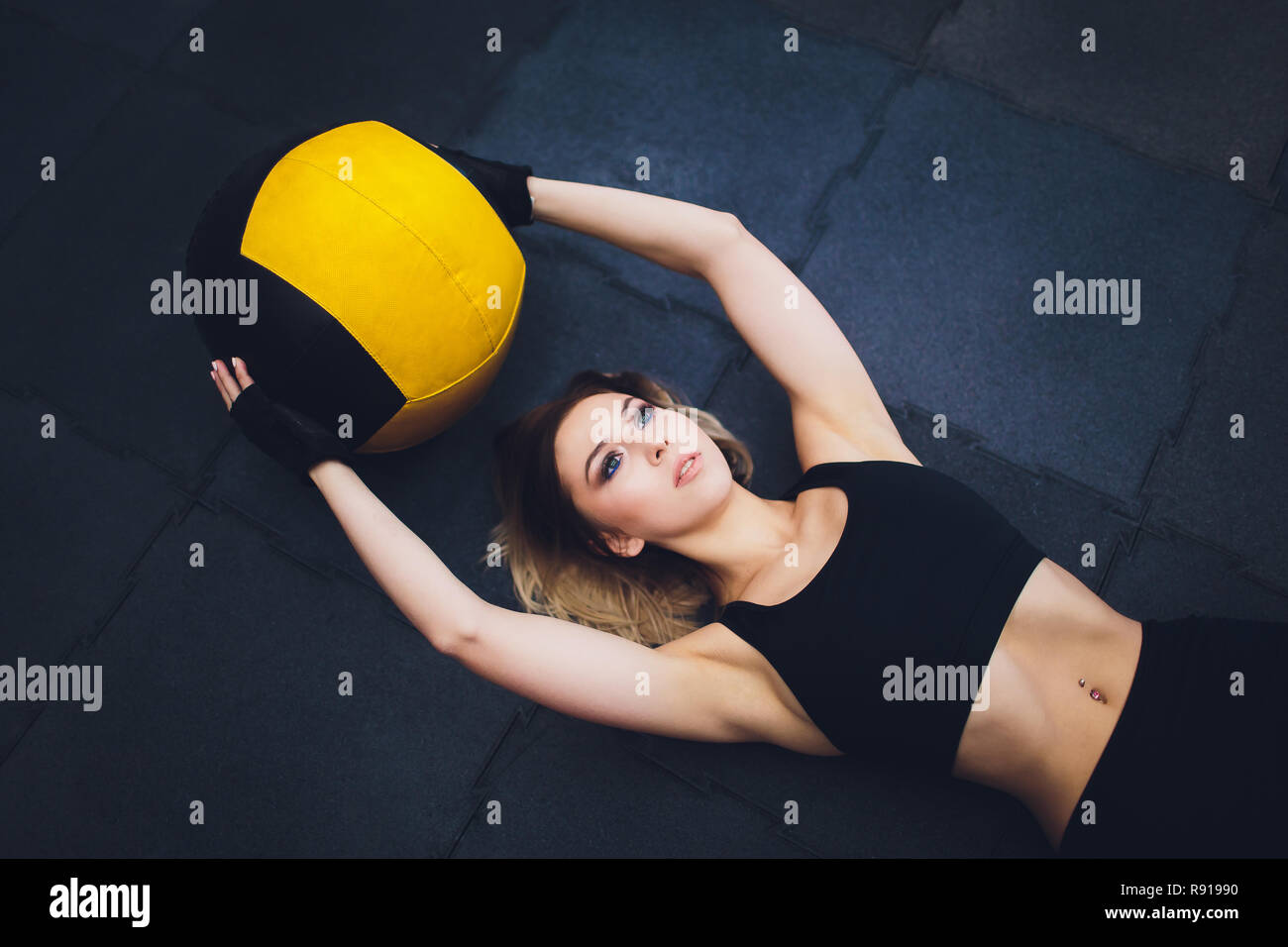 Female fitness model exercising with medicine ball at gym. Young woman ...
