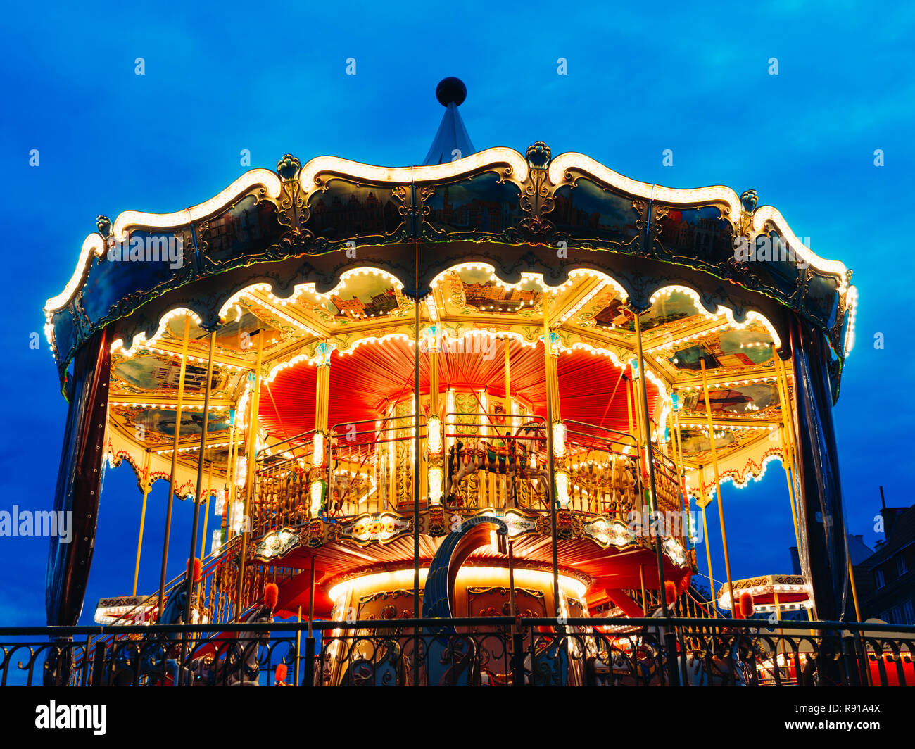 Carousel at an amusement park in the evening and night illumination - a ...