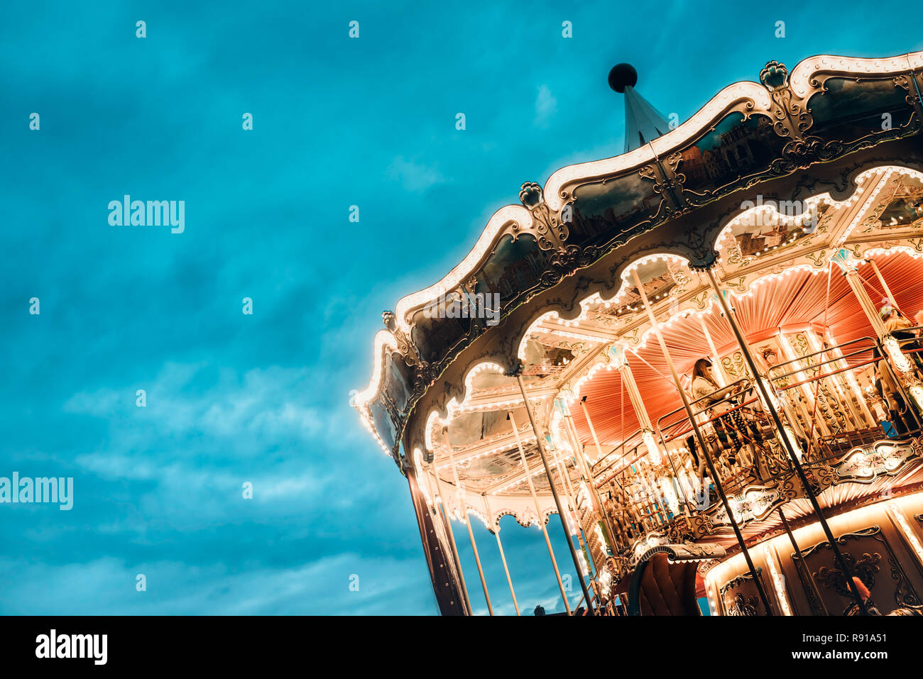 Carousel at an amusement park in the evening and night illumination - a ...