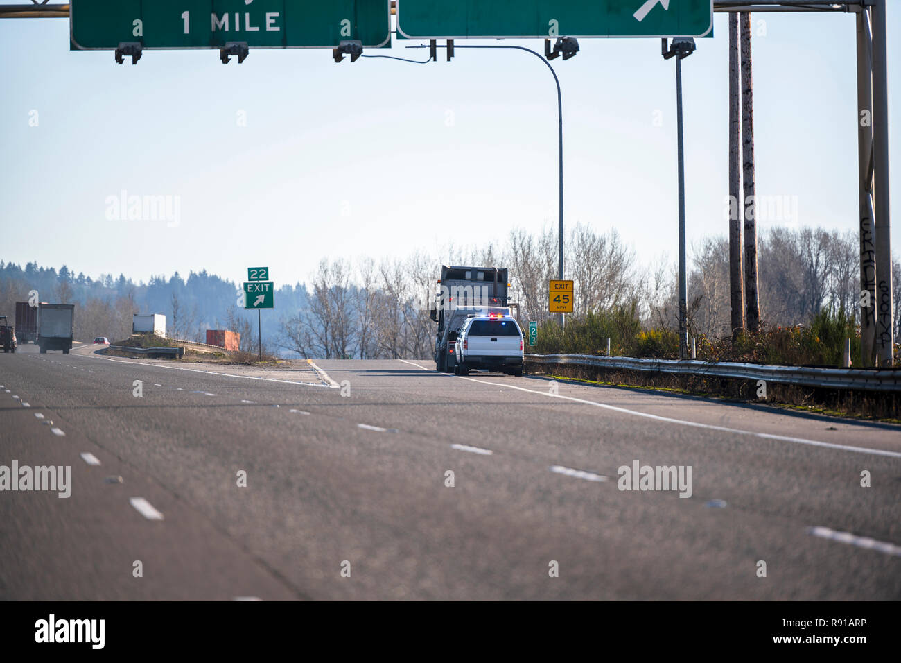 A patrol policeman on a truck with flashing lights stopped a big rig ...