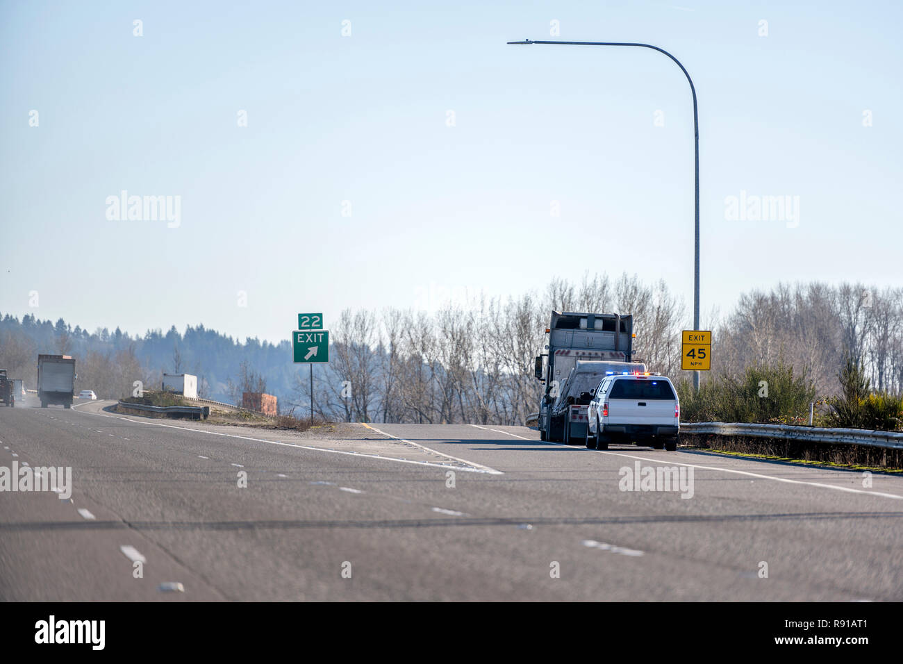 A patrol policeman on a truck with flashing lights stopped a big rig ...