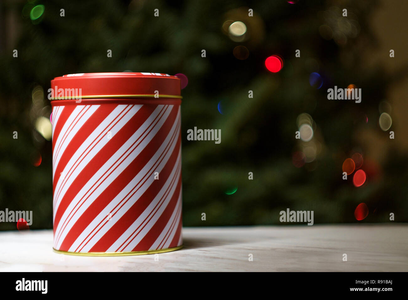 Christmas lights on tree in background with candy cane colored ...