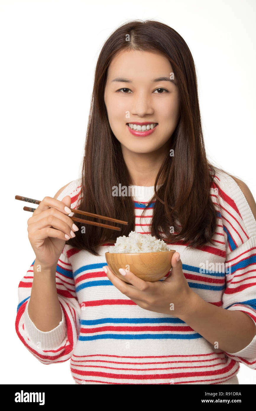 Beautiful Asian American woman eating a bowl of rice isolated on a ...