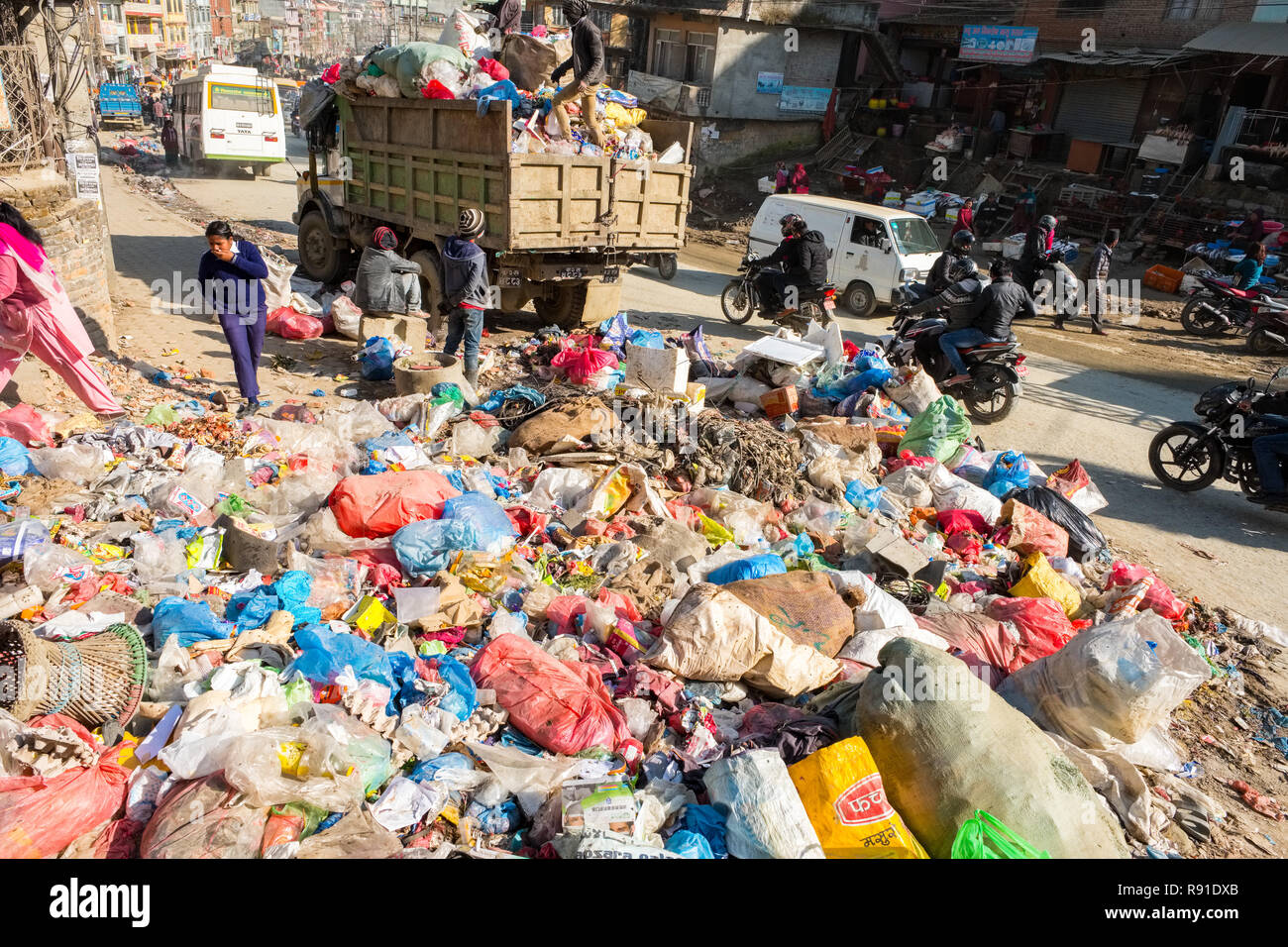 Piles of rubbish / waste/ trash being cleared from street into a lorry ...