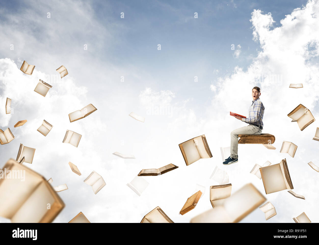 Man reading book and many of them flying in air Stock Photo - Alamy