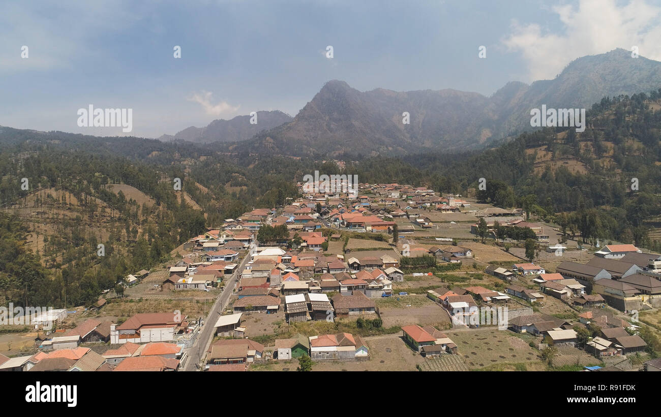 village in mountain valley. mountains with farmlands, village, fields ...