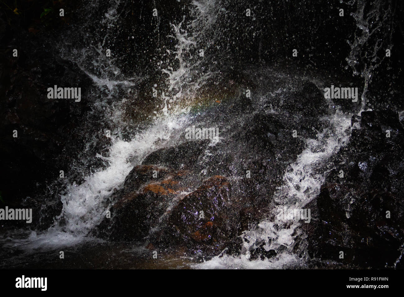 Water falling on stone in the forest black background Stock Photo - Alamy