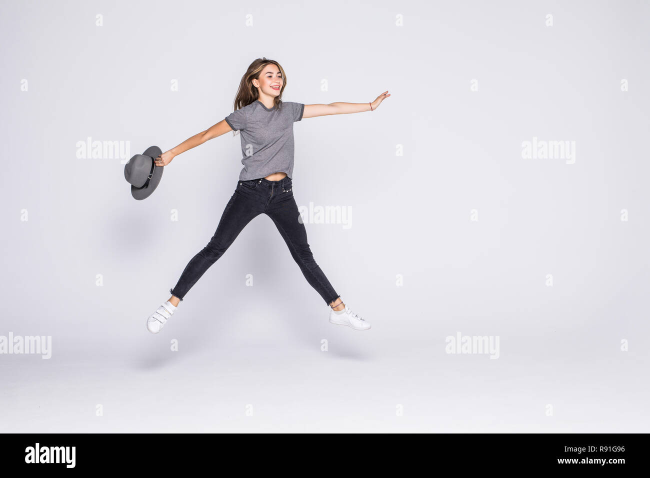 Full length portrait of a cheerful cute woman jumping isolated on a ...